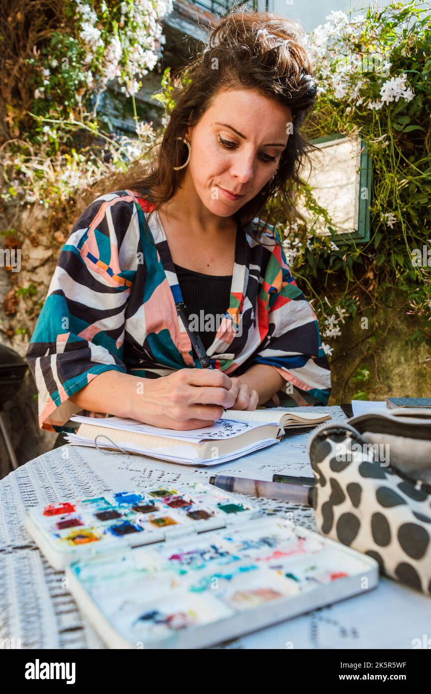 vertical shot of an adult caucasian female artist at home sitting ...