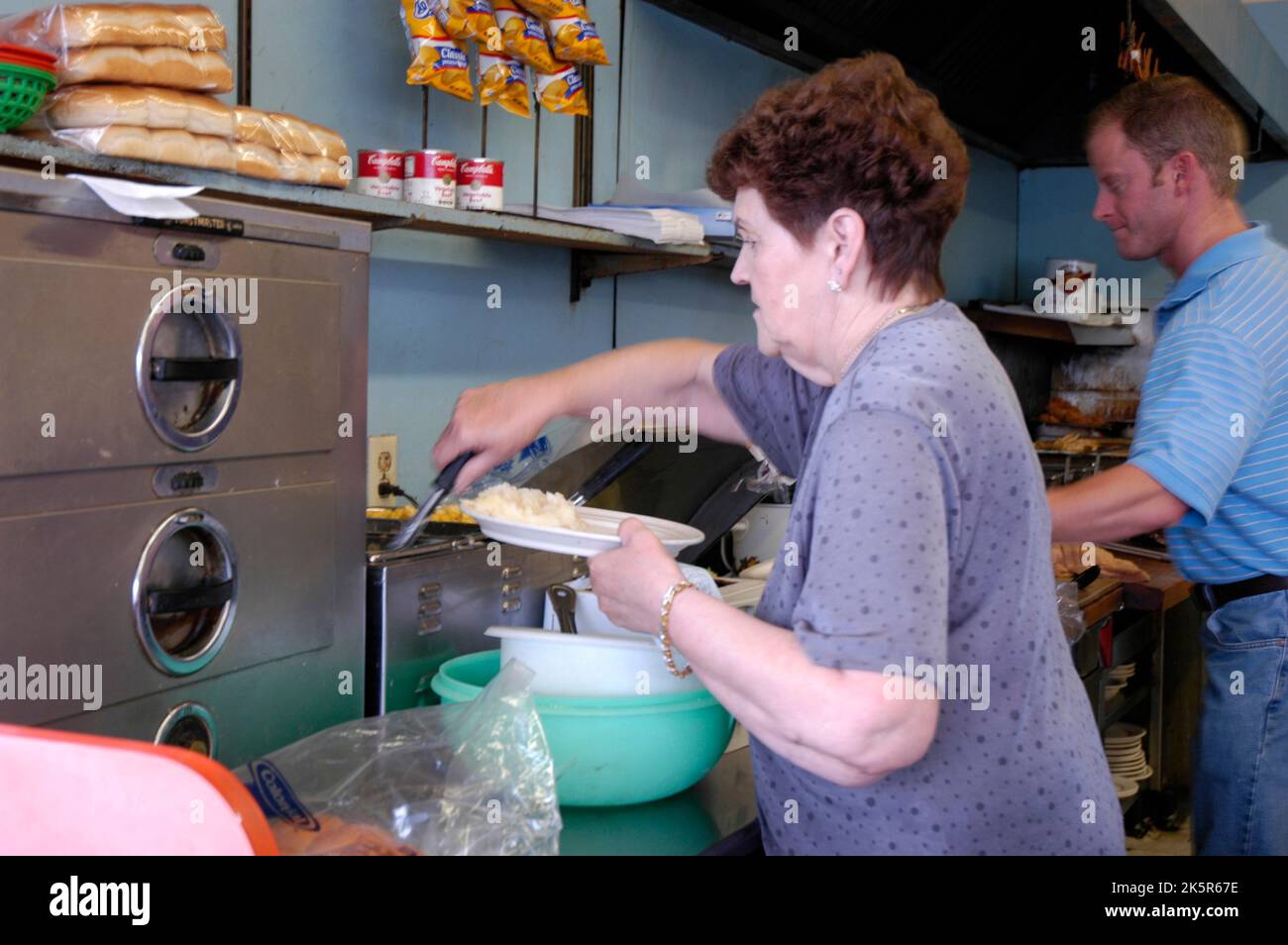 Senior woman short order cook working at her age making a living in ...