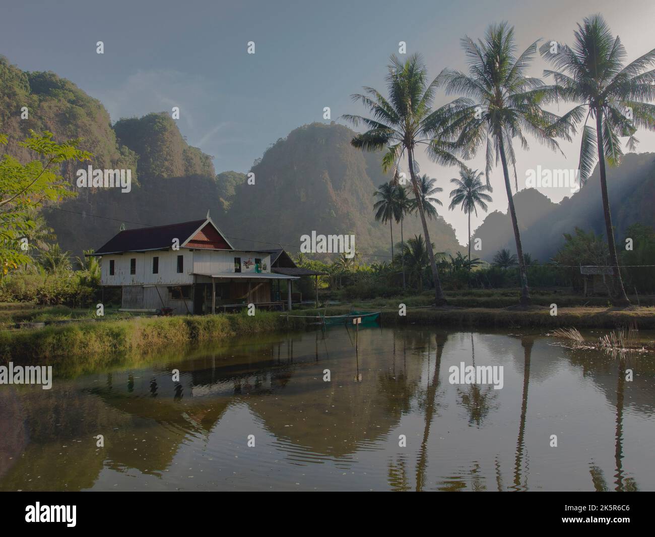 A simple house with karst mountain and blue sky as background at ...