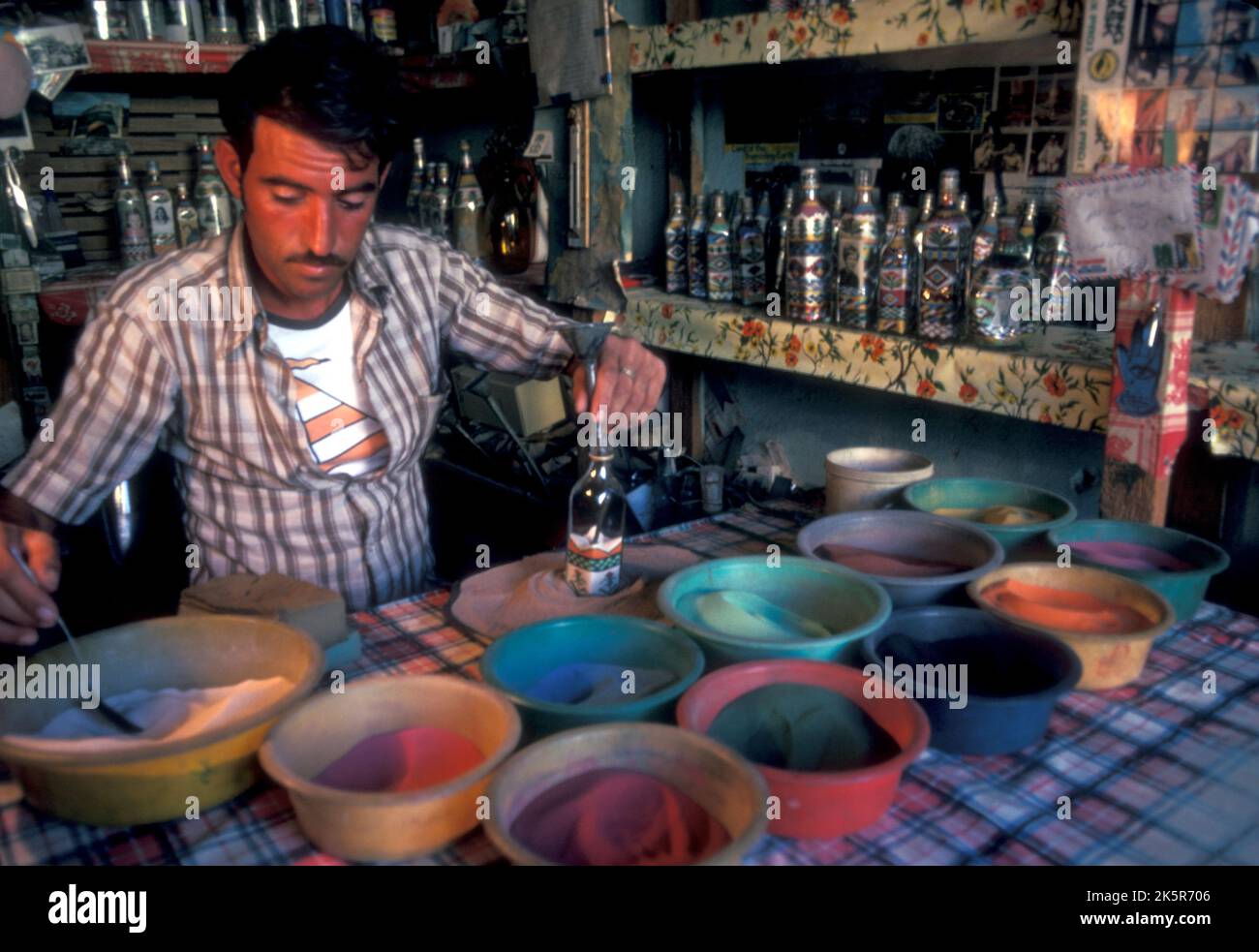 A sand artist making patterns to sell to tourists in Aqaba, Jordan ...