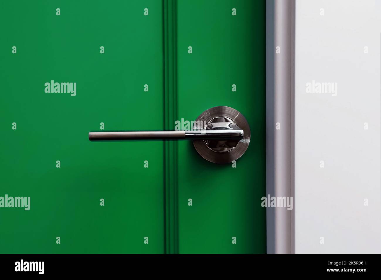 Close-up of green door with modern design handle Stock Photo - Alamy