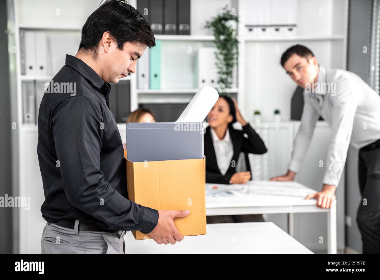 Depressed and disappointed employee packing his belongings after being ...