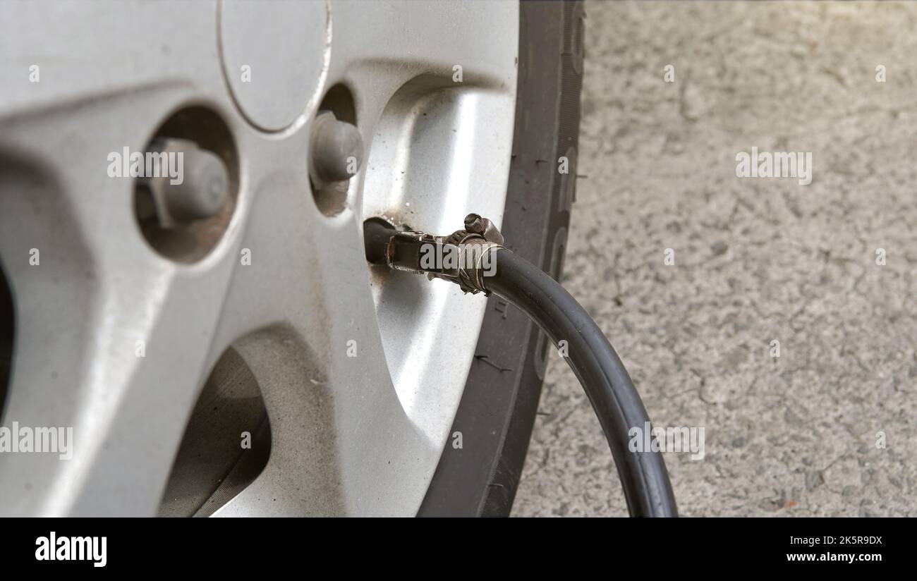 Filling air in the tires of car or inflating tire in selective focus ...