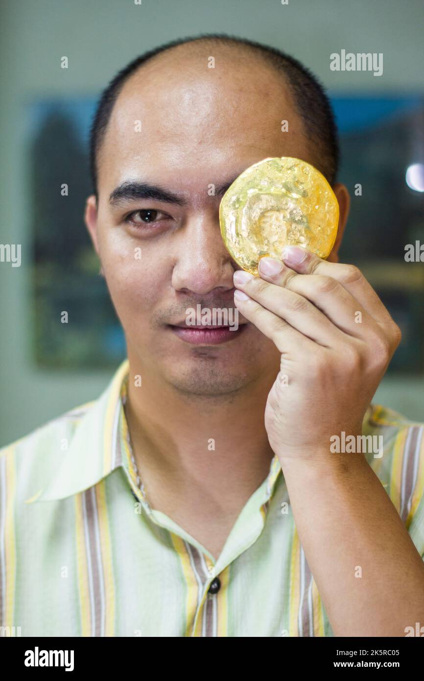 A man holds a gold disc mined and processed by a mining company at ...