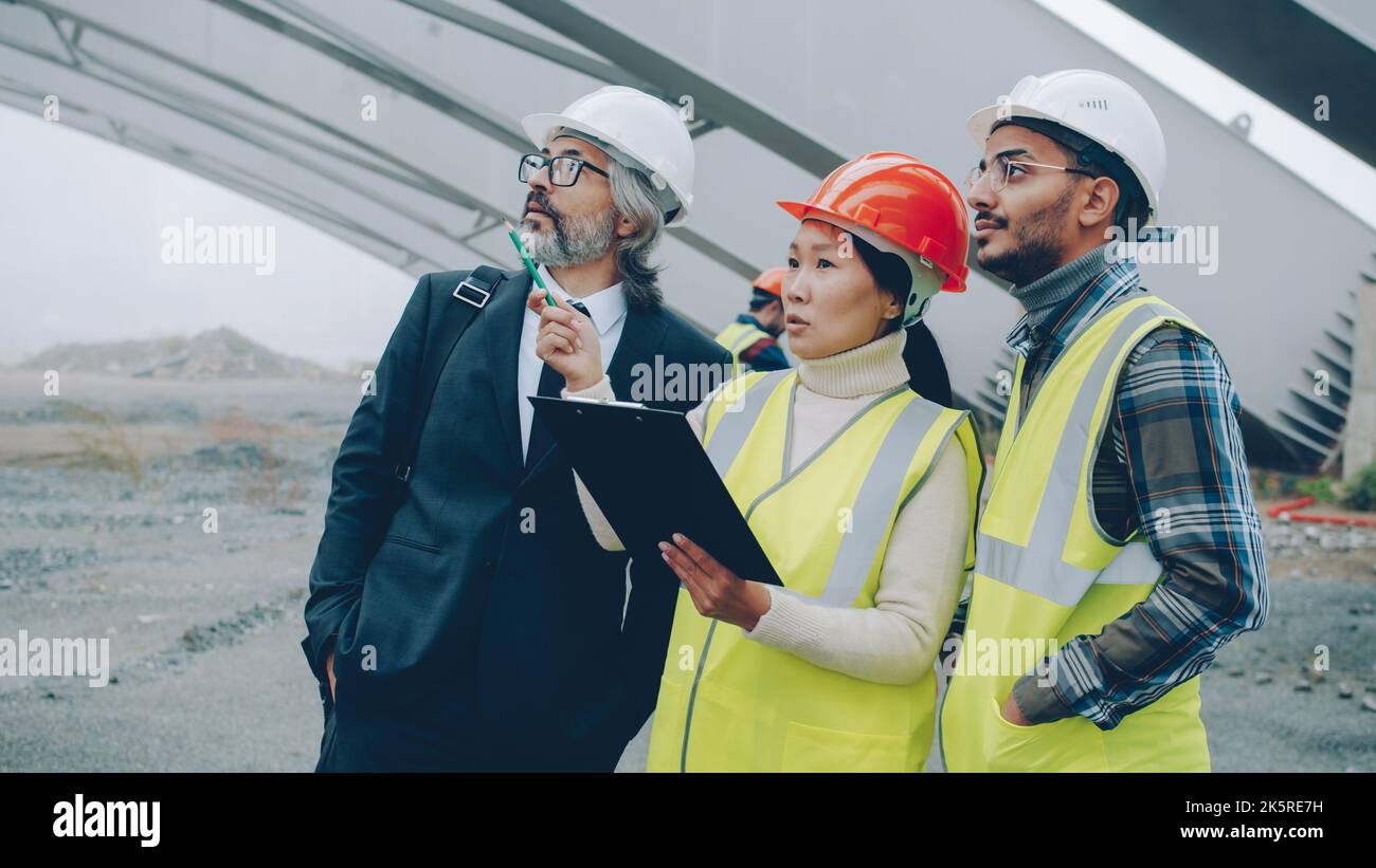 Multiracial group of workers are talking to construction inspector ...
