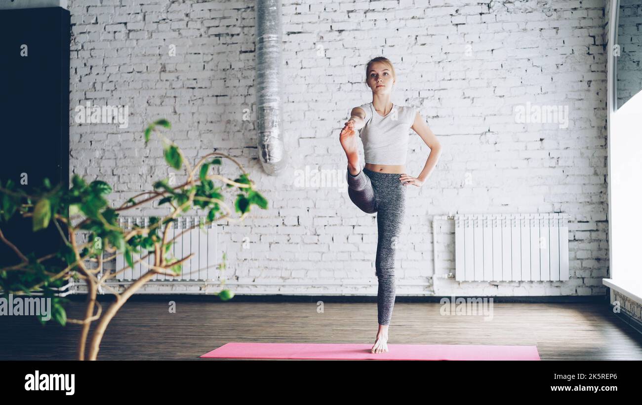 Starting female yoga student is doing sequence of balance exercises in ...