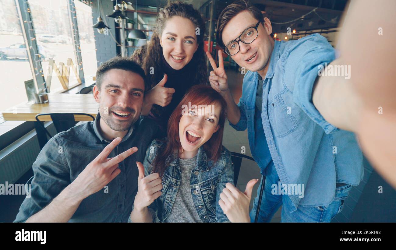 Point of view shot of cheerful friends taking selfie in pizzahouse ...