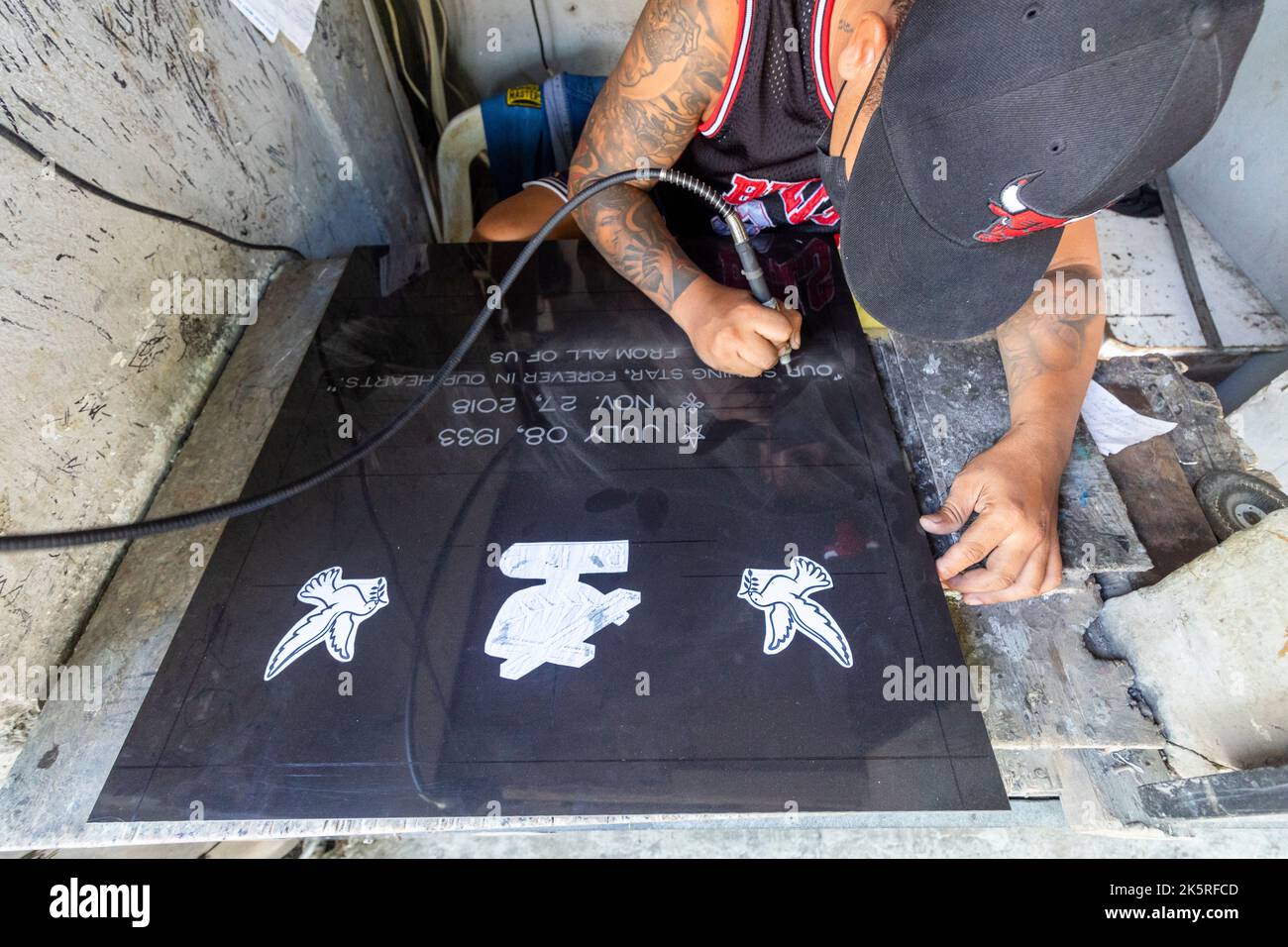 A lapida maker working on a marble tombstone in Cebu City, Philippines ...