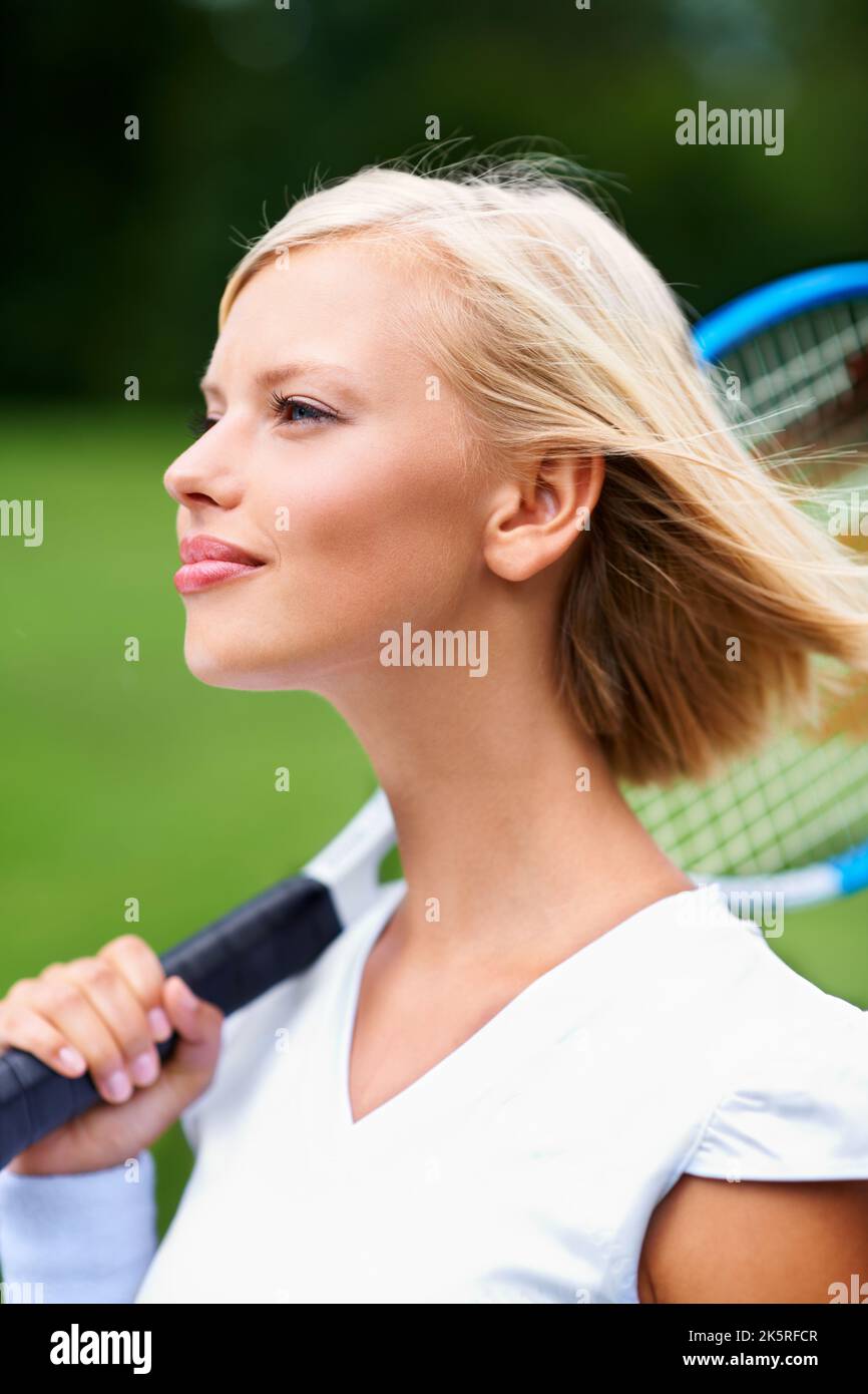 Keeping her eye on the ball. A young tennis player with the wind in her ...