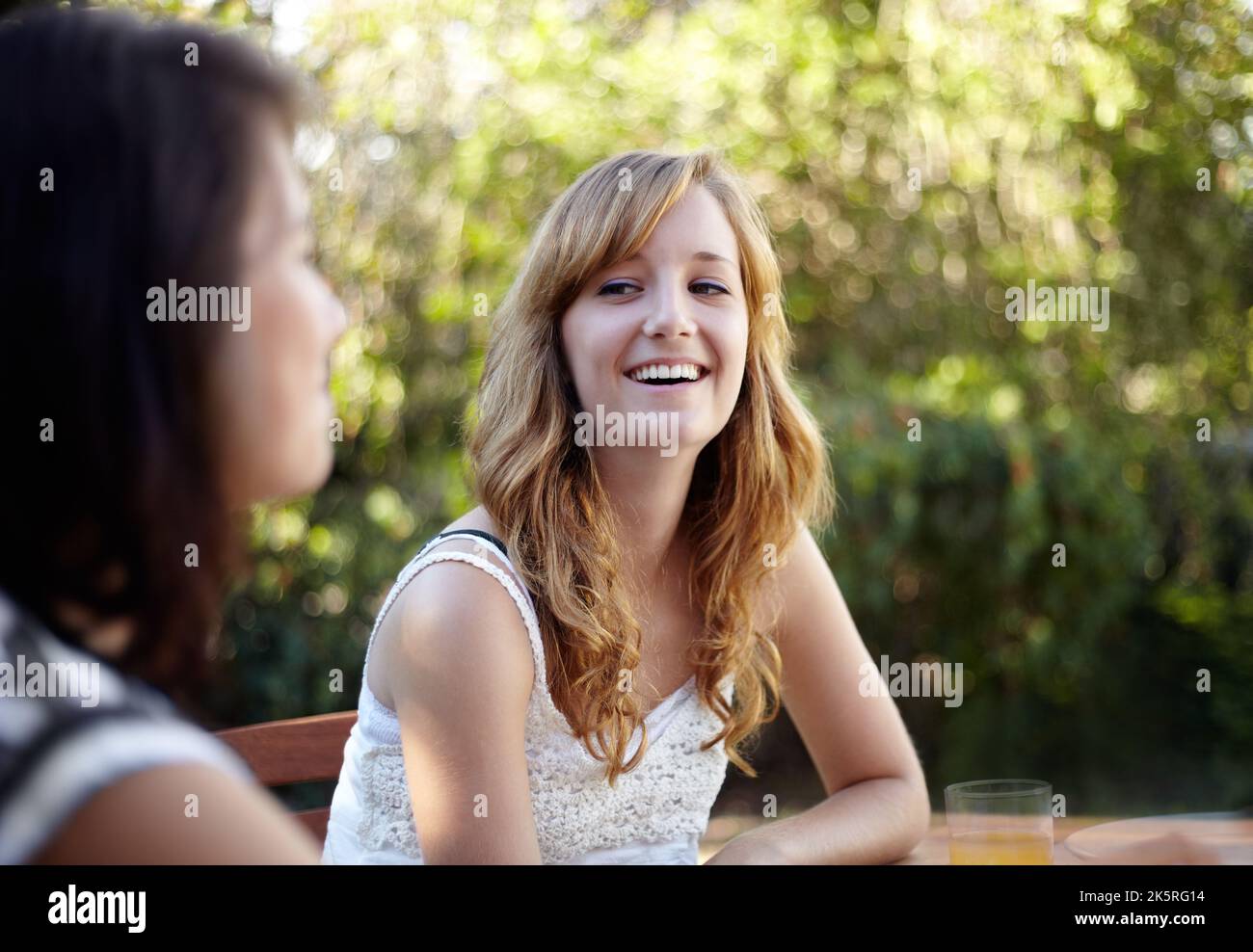 Sharing a laugh between friends. Smiling young teen at a lunch with a ...