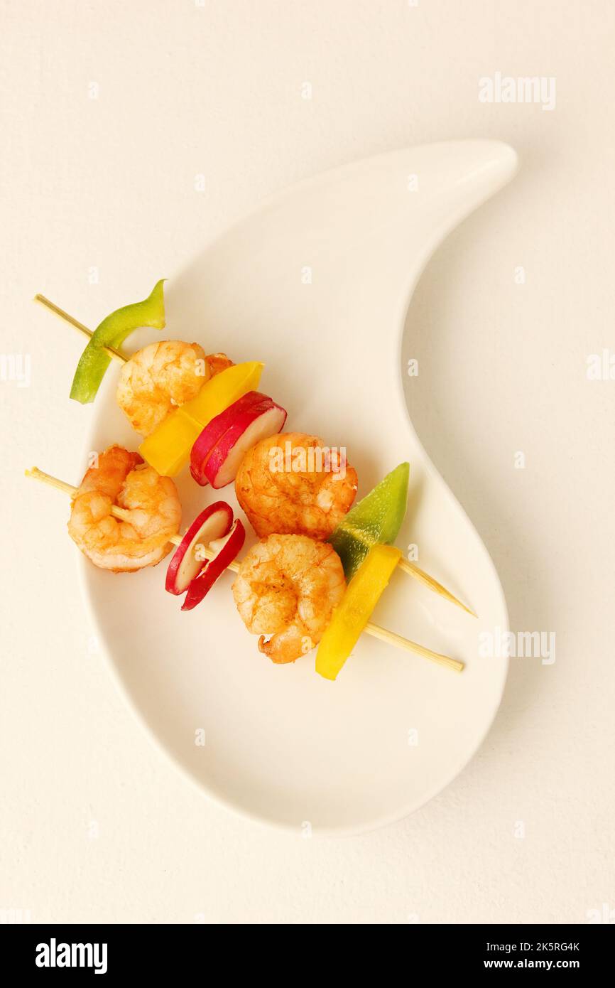 Perfect prawns. Closeup of two prawn skewers on a white background ...