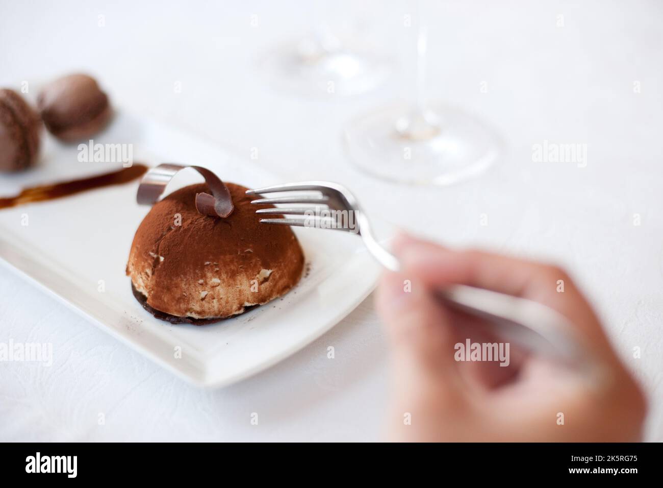 Divine dessert. an unrecognizable person reaching for a bit of an ...