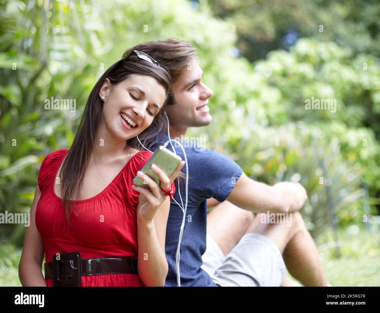 Loving young couple in summer park listening music hi-res stock ...