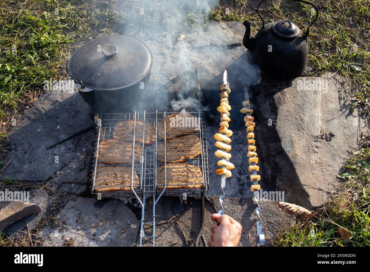 Close-up of pieces of pork lard roasting on campfire. Top view ...