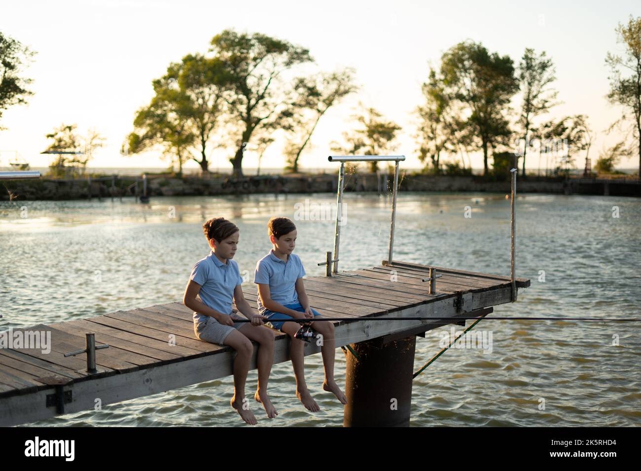 Boys fishing at sunset on the lake. Summer hobby and leisure Stock ...