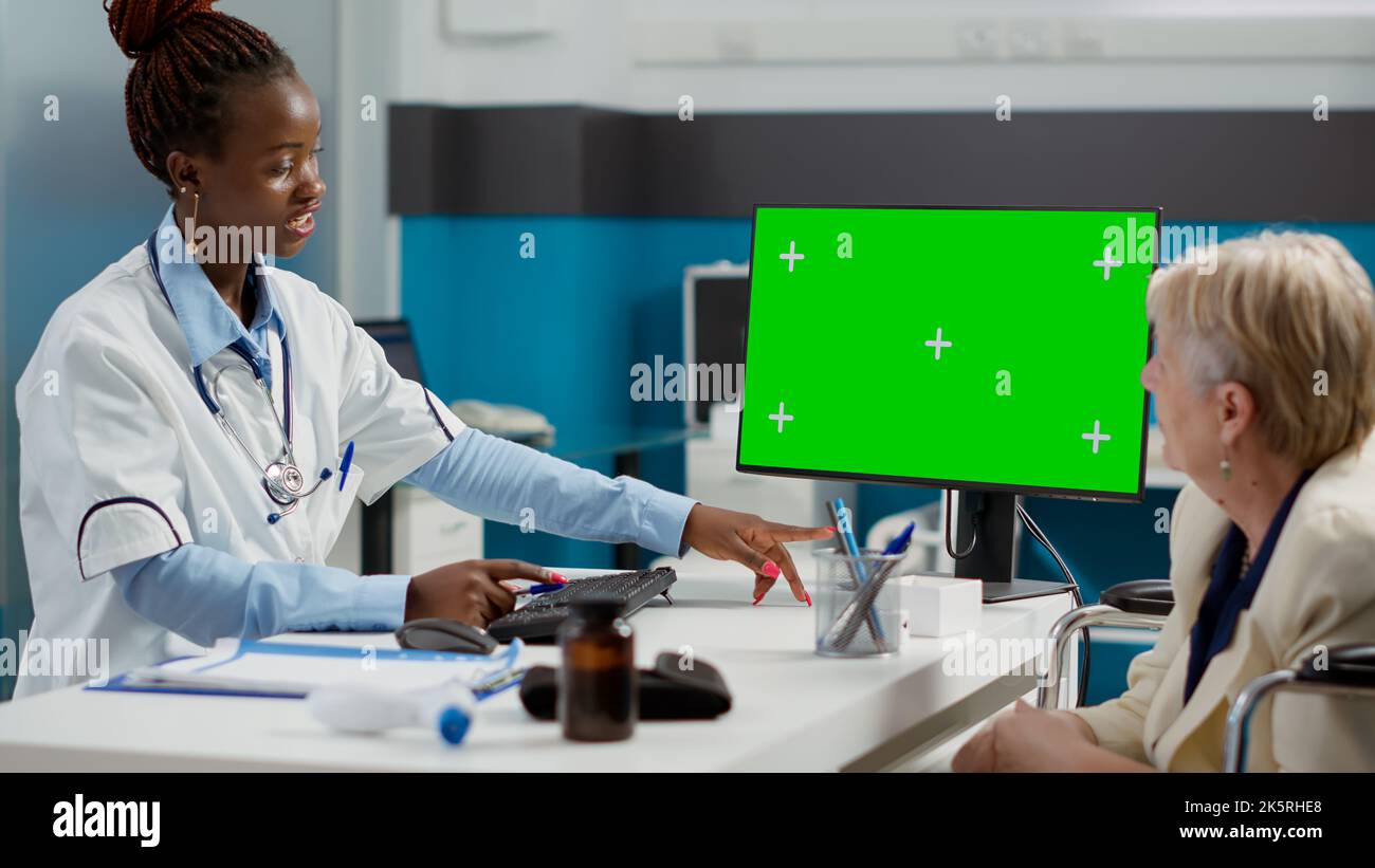 Female medic and paralyzed patient analyzing greenscreen on monitor ...