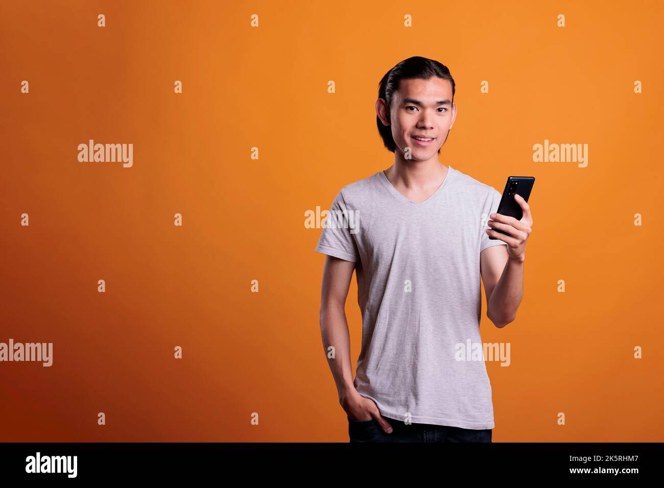 Young asian man messaging on smartphone, using social media. Cheerful ...