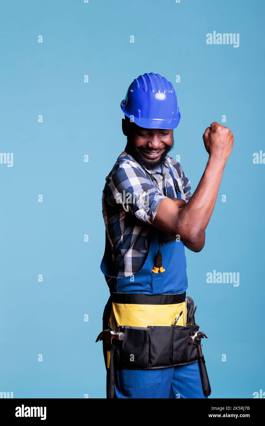 Strong man flexing arm muscles, preparing to work on construction ...