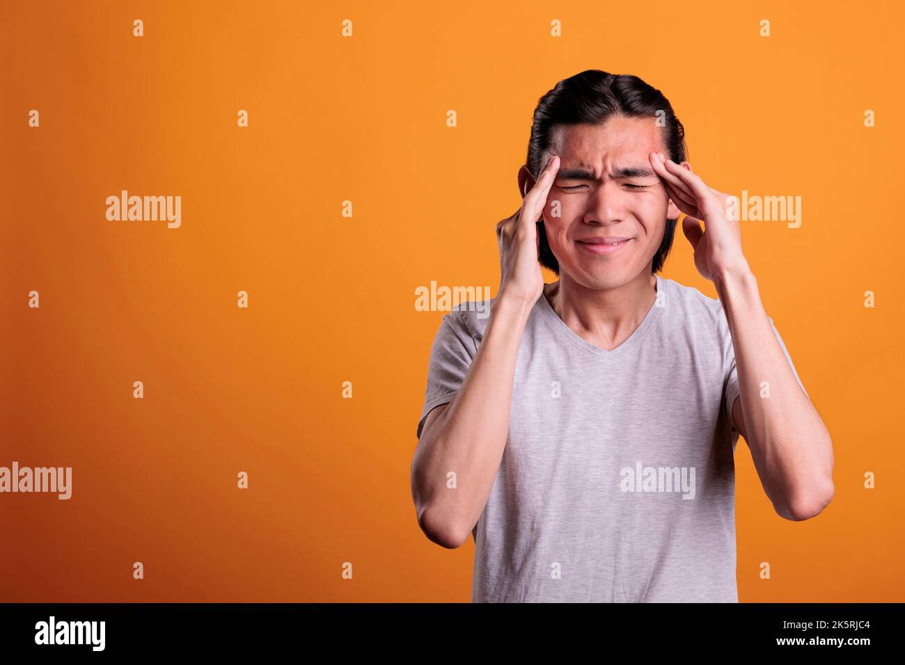 Young man having headache, touching temples with fingers. Exhausted ...