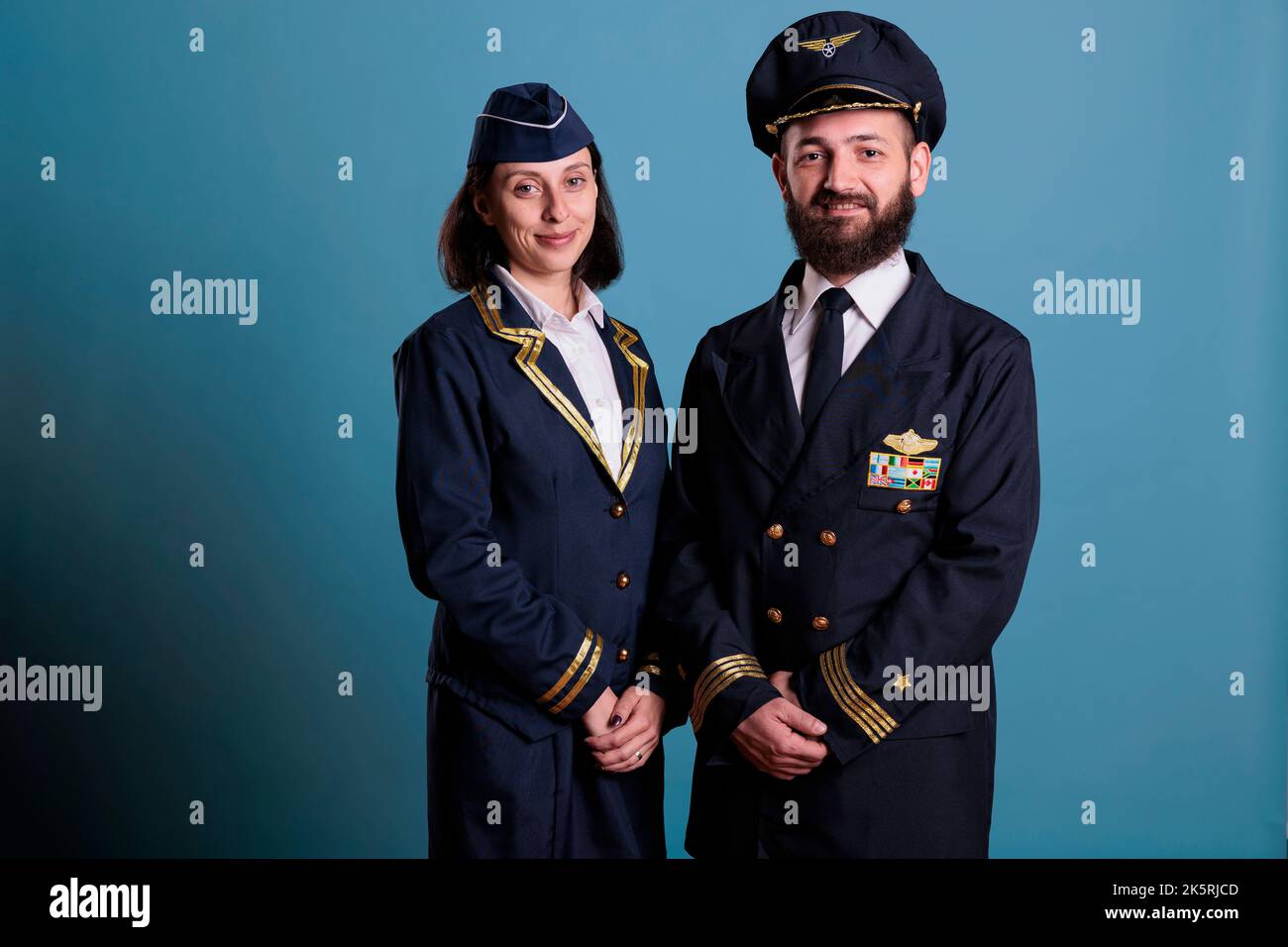 Smiling airplane pilot and flight attendant in professional uniform ...