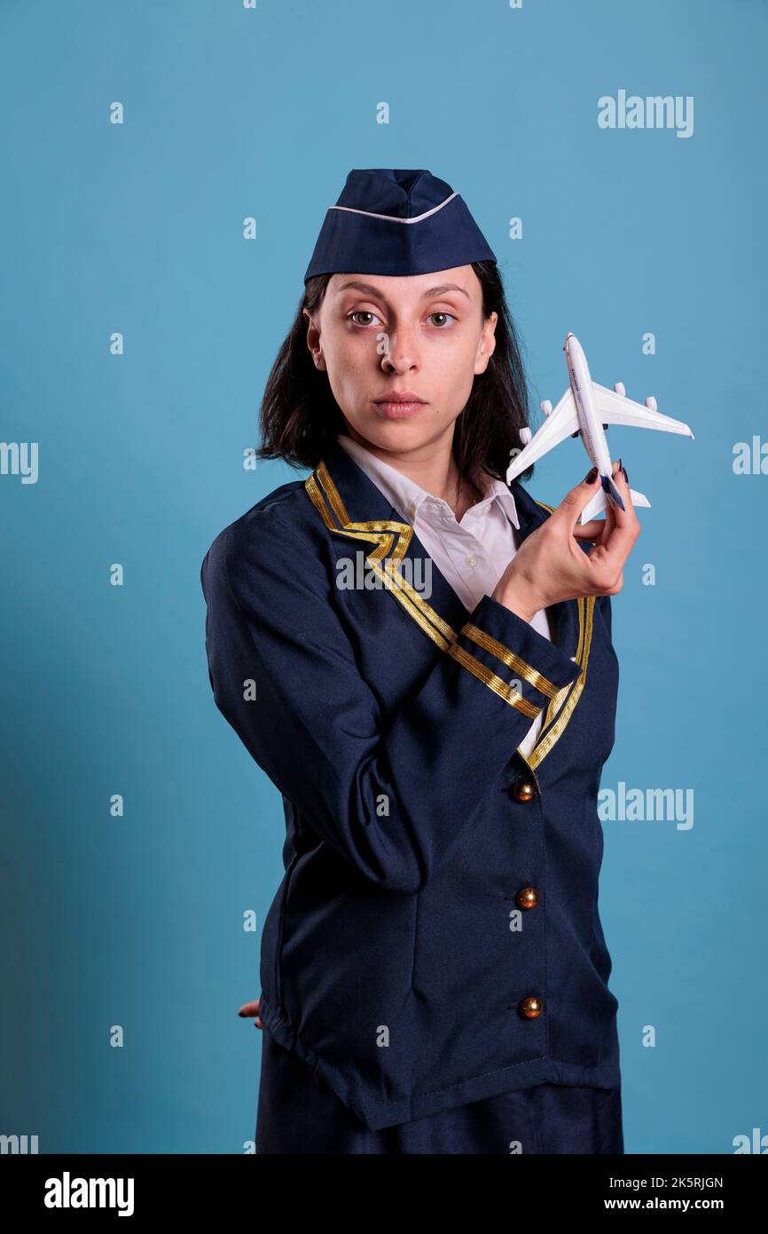 Flight attendant in aviation uniform holding airplane model ...