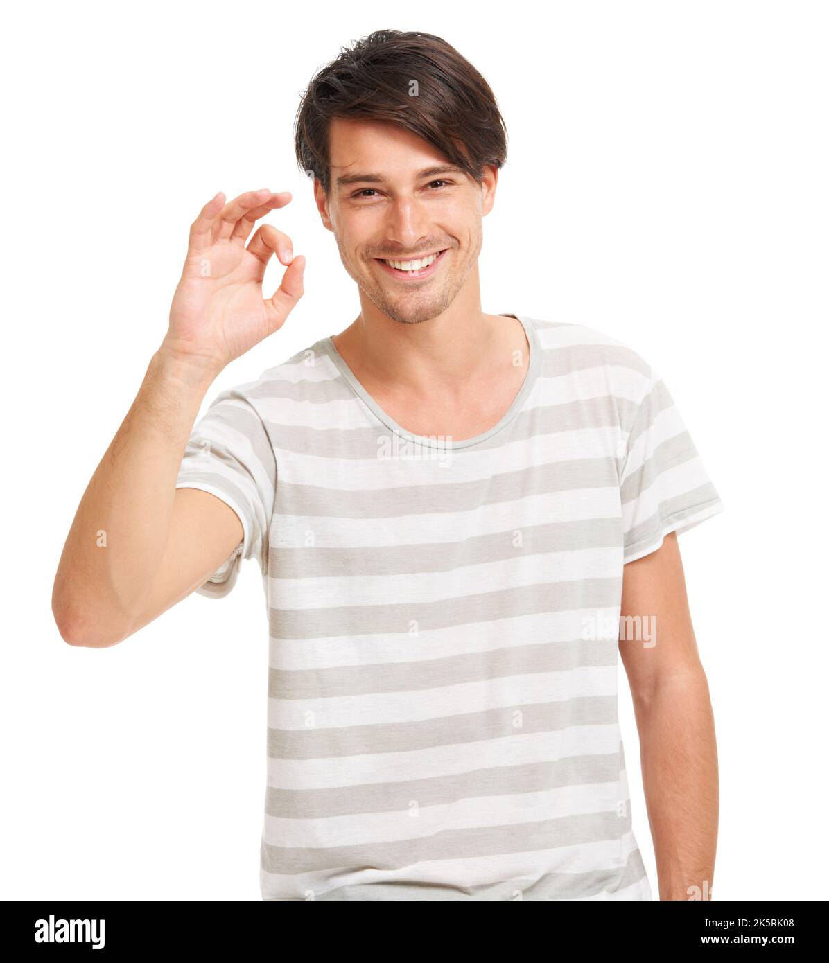 Getting it just right. Smiling young man holding up his hand in the ...