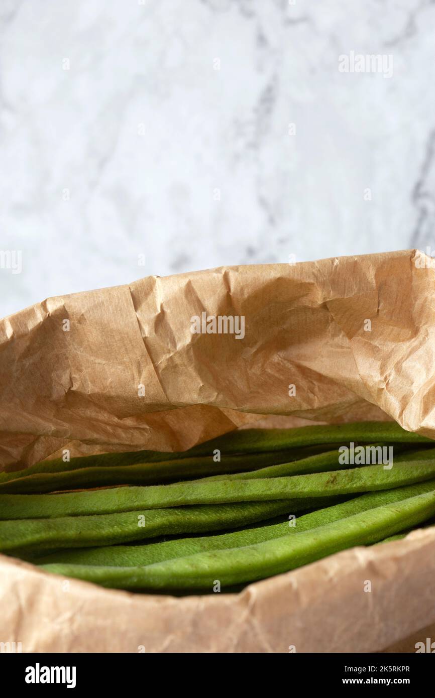 Raw green beans in a brown paper bag. Eco friendly recycling packaging ...