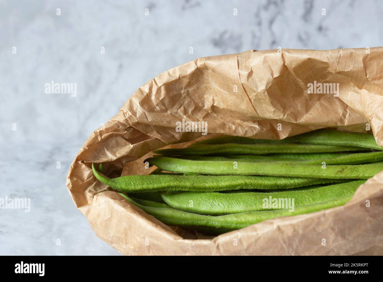 Raw green beans in a brown paper bag. Eco friendly recycling packaging ...