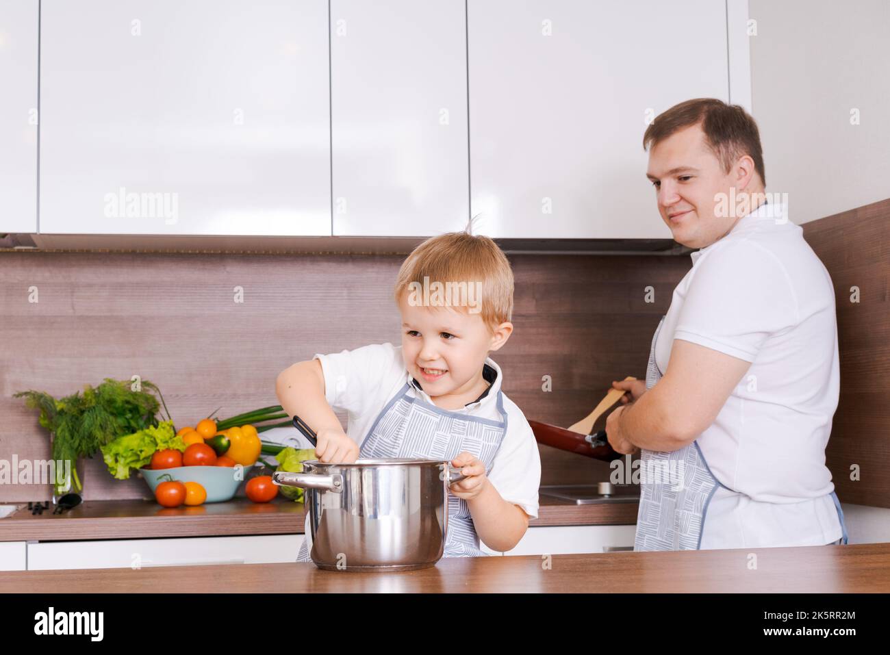 Family cooking in household dad with son, cook dinner for mom, have fun ...