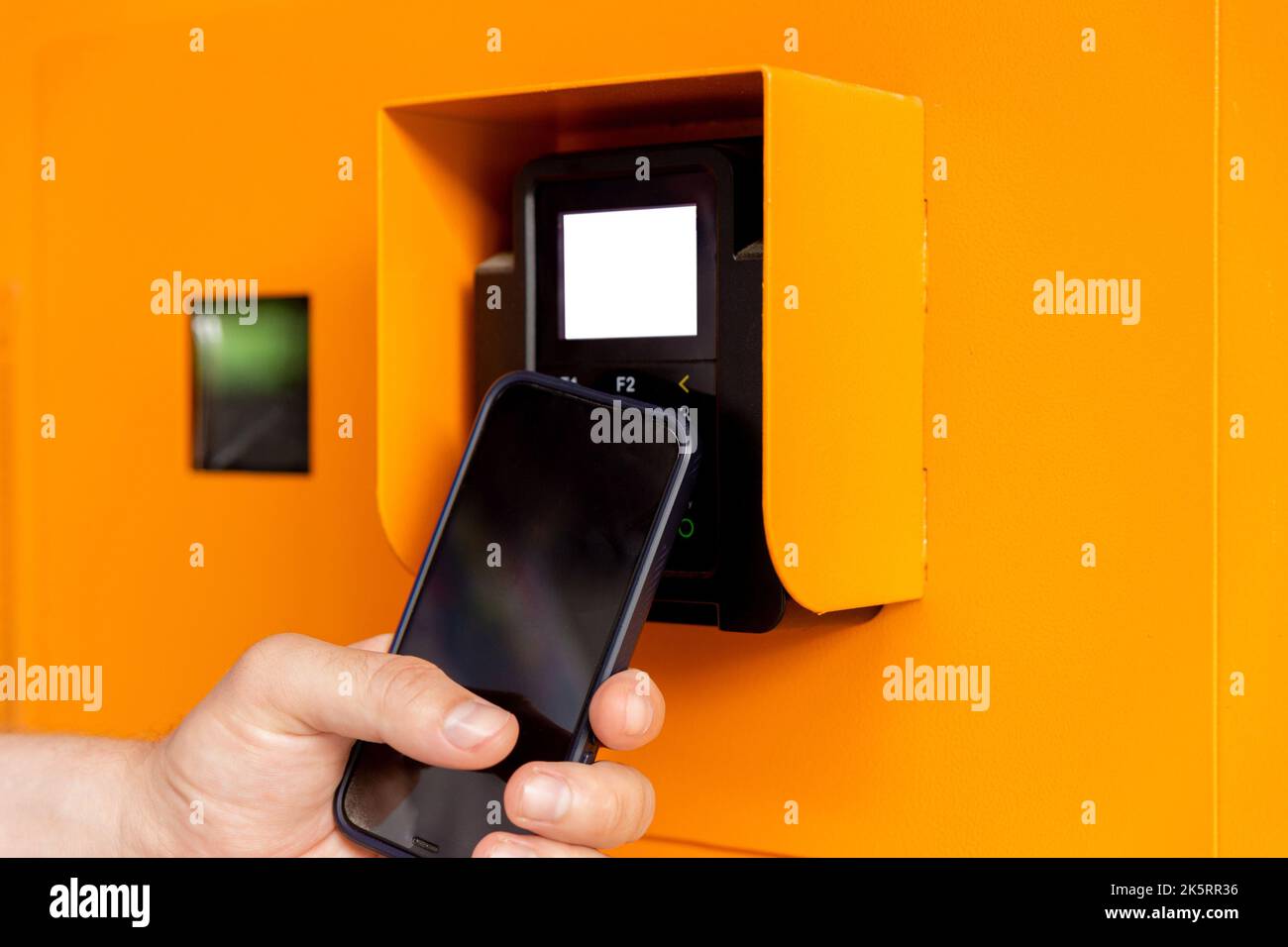 Man using NFC technology on smart phone to enter the code and recieve ...