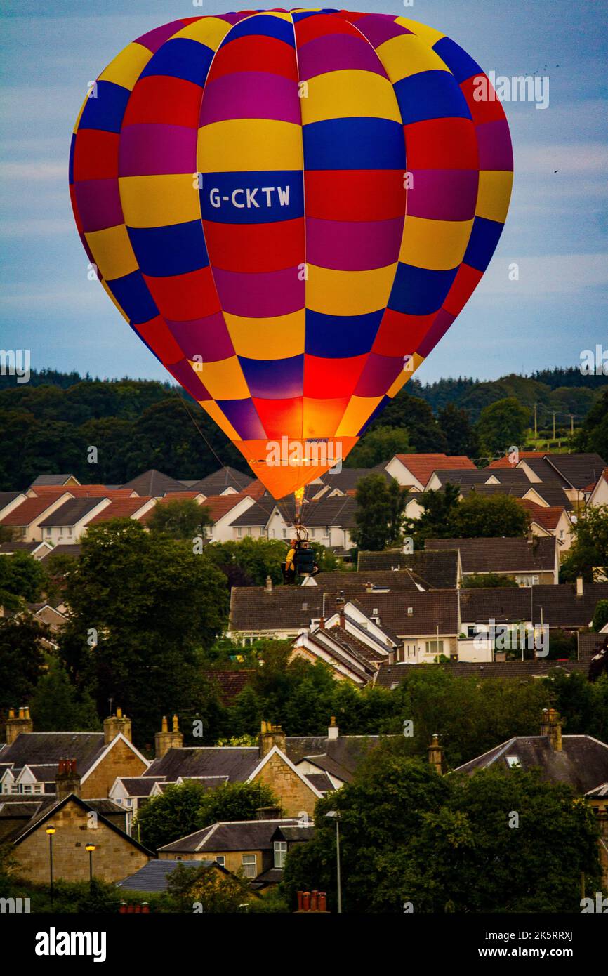 A vertical shot of a colorful hot air balloon floating over the ...