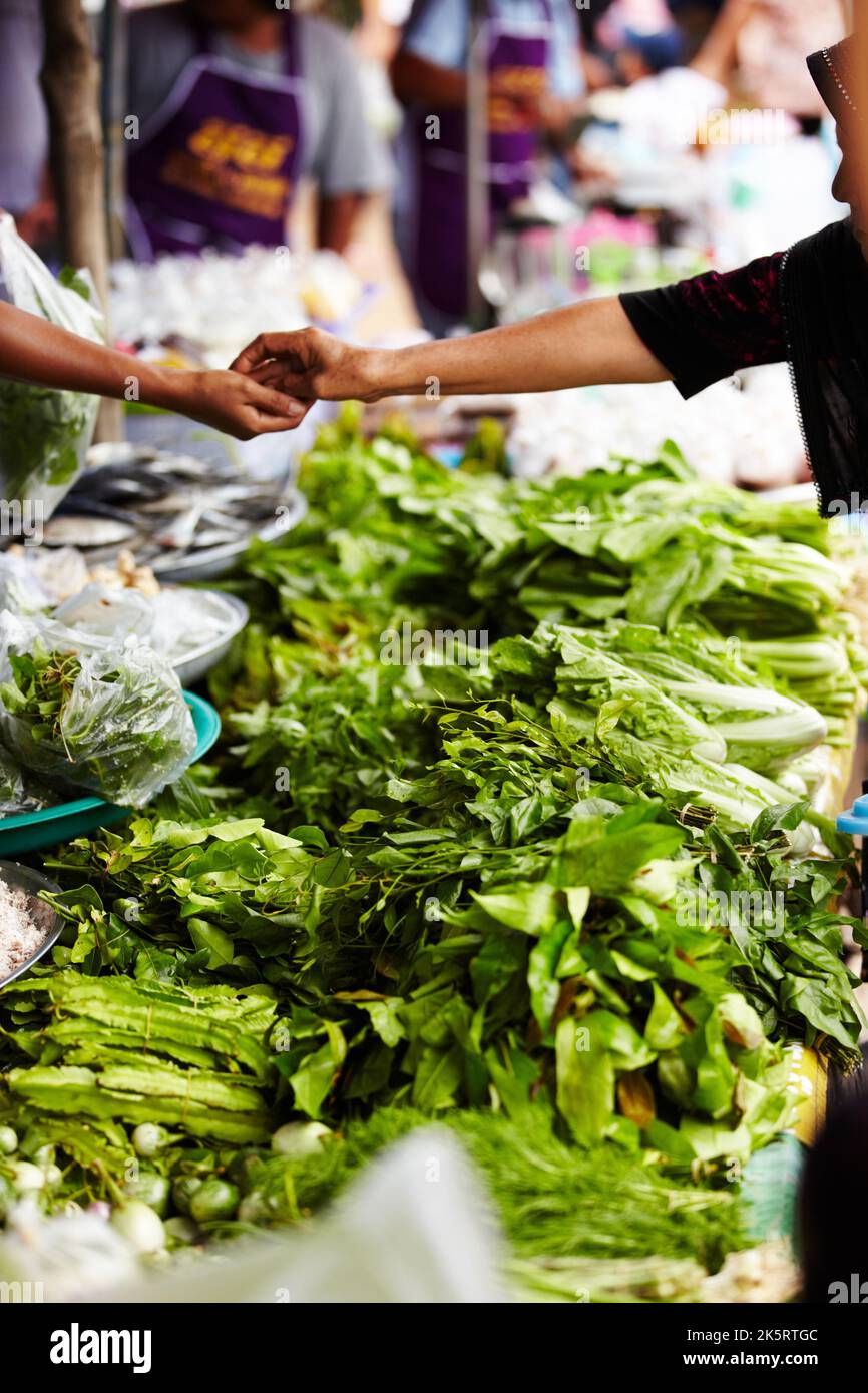 Supporting local traders. Purchasing some vegetables at a Thai herb ...