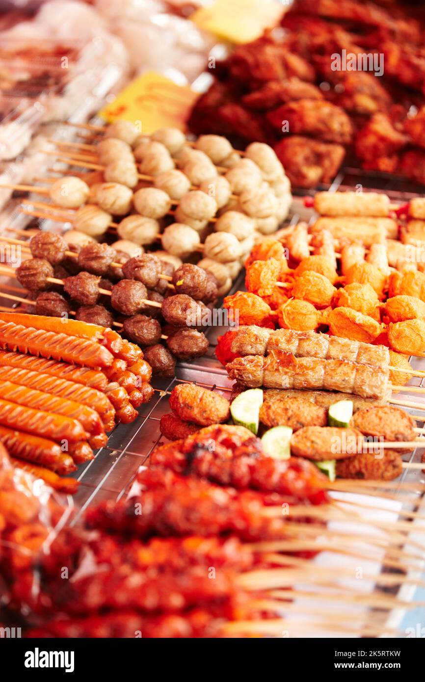 Street meat vendors. A market stall with a variety of meat snacks on a ...