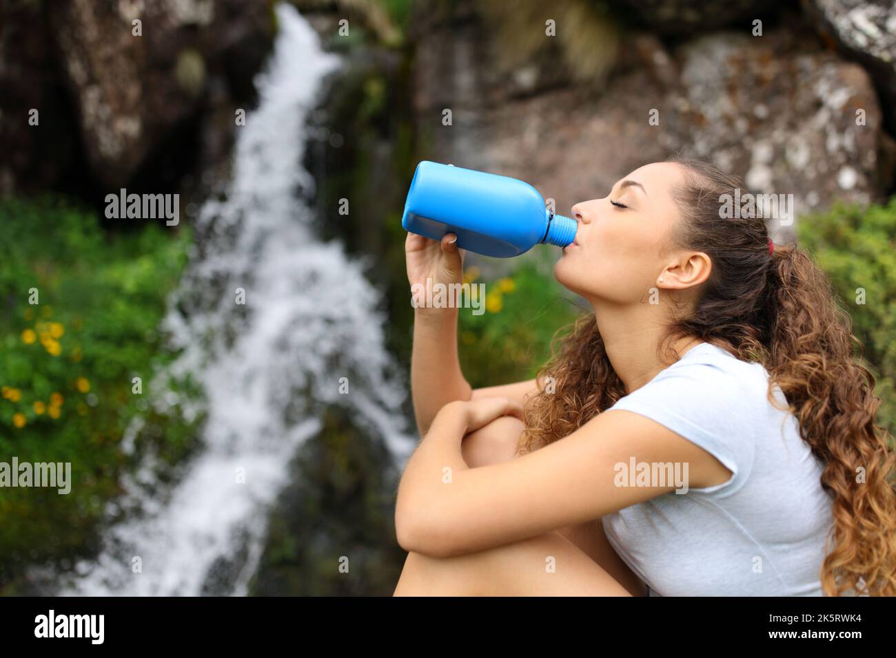 Profile of a woman drinking water from canteen in a waterfall Stock ...