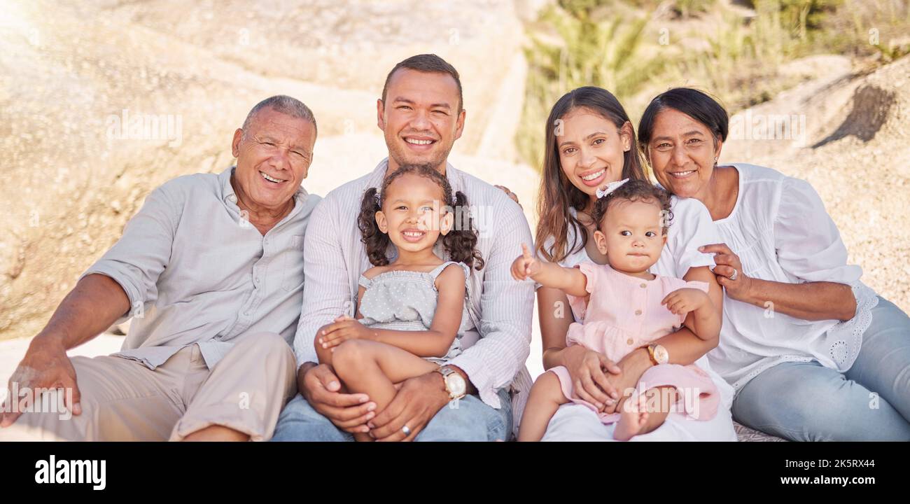 Portrait of a smiling mixed race family with little girls sitting ...