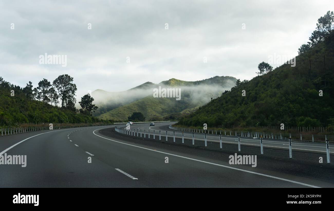 Cars travelling on motorway with fog drifting among the hills. Hamilton ...