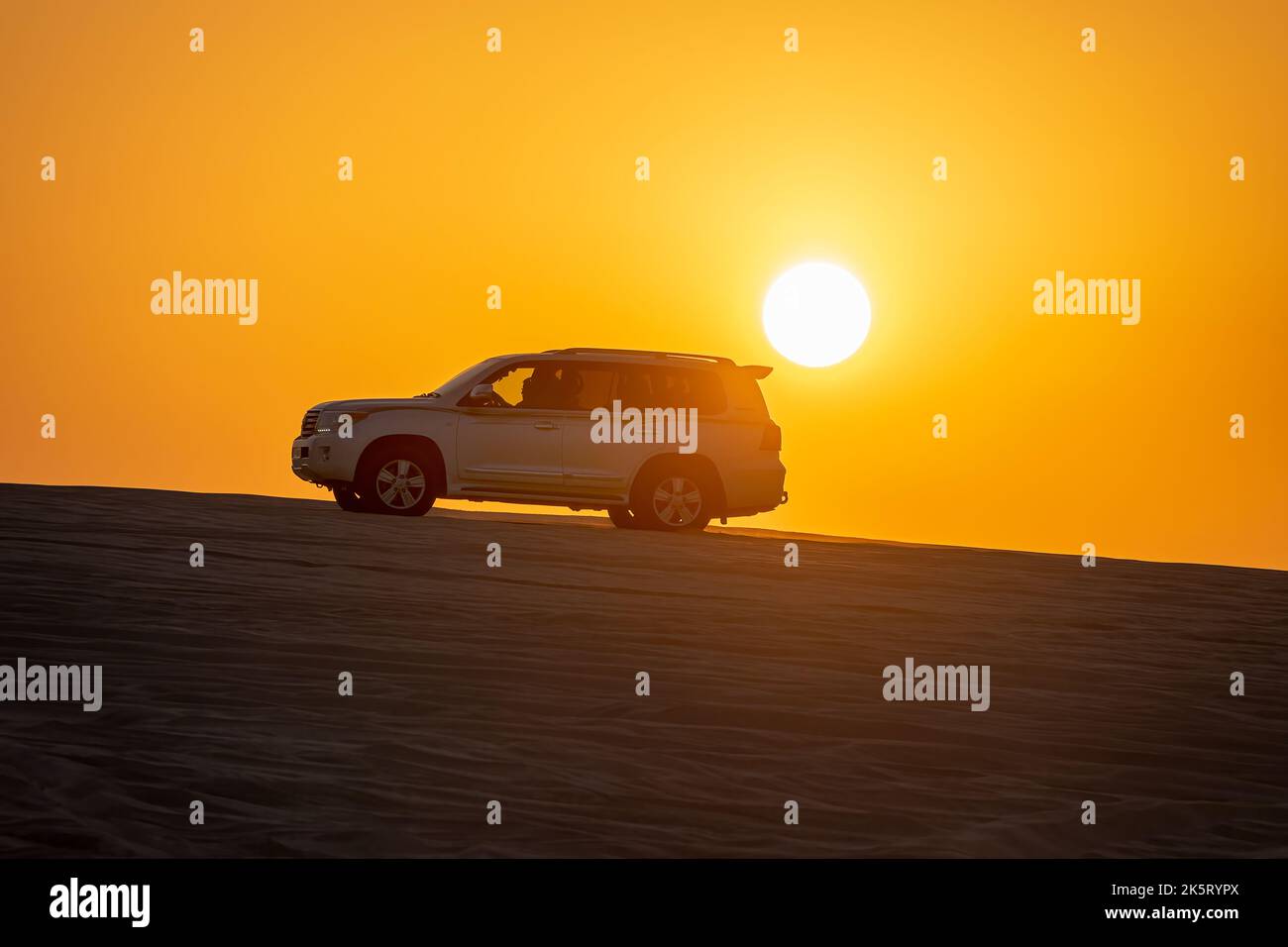 Toyota Landcruiser 4WD driving through dunes at sunset time. dune ...