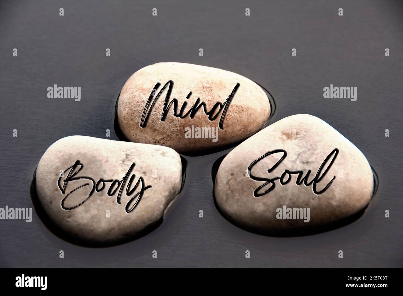 Mind, Body and Soul words engraved on stones Stock Photo - Alamy