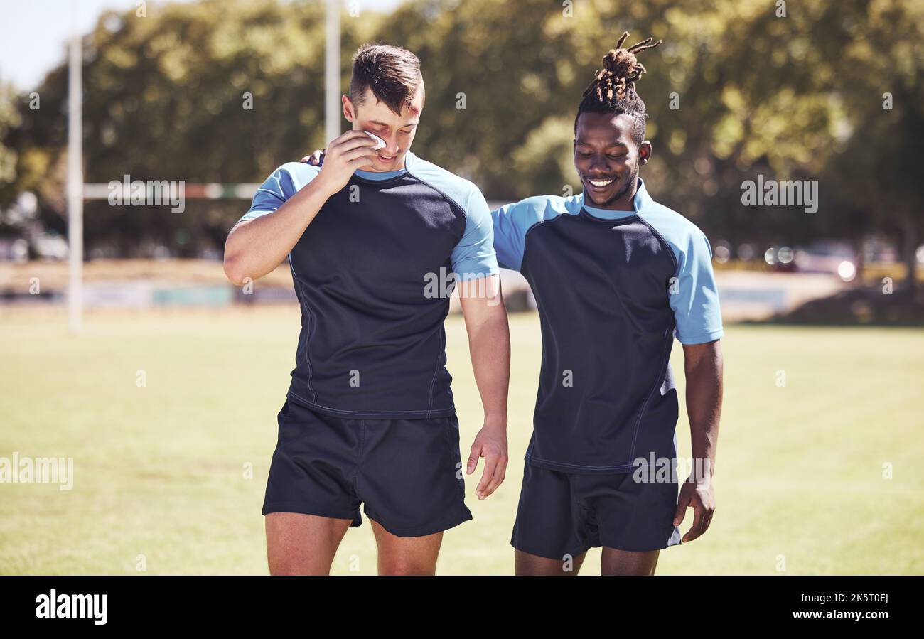 Two diverse young rugby players standing outside on the field. Black ...