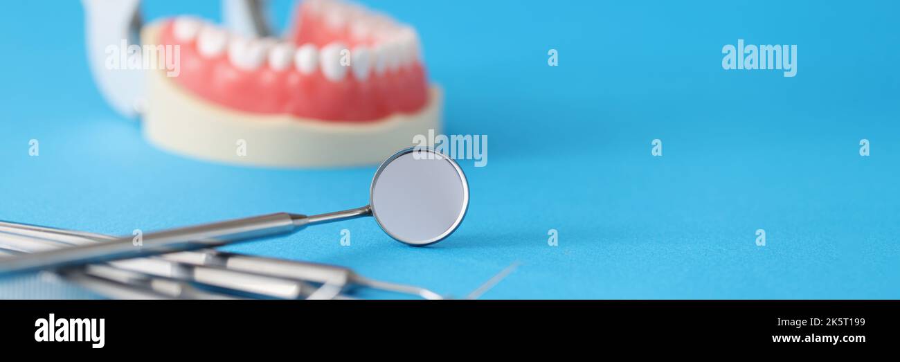 Dental tool and dental open jaw on blue background Stock Photo - Alamy