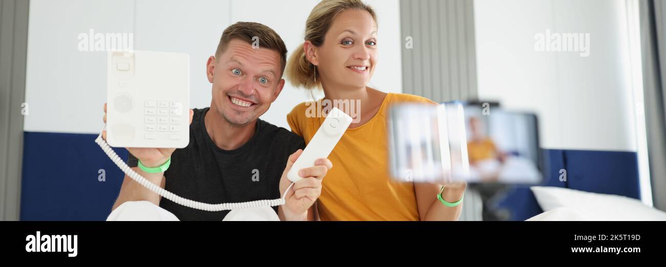 Family of bloggers hold push-button phone and shoot video camera hotel ...