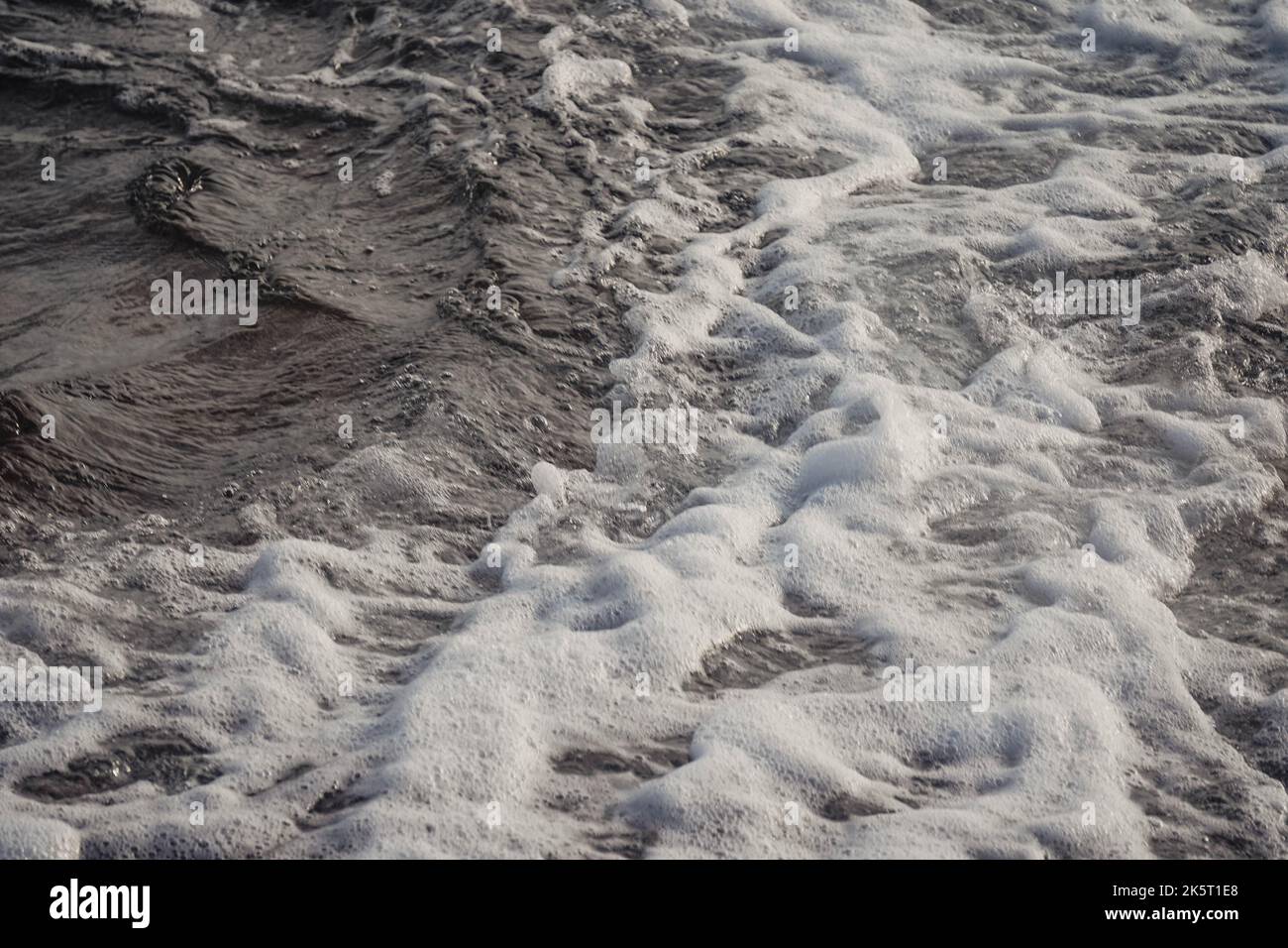 Landscape of a beach shore with waves and foam Stock Photo - Alamy