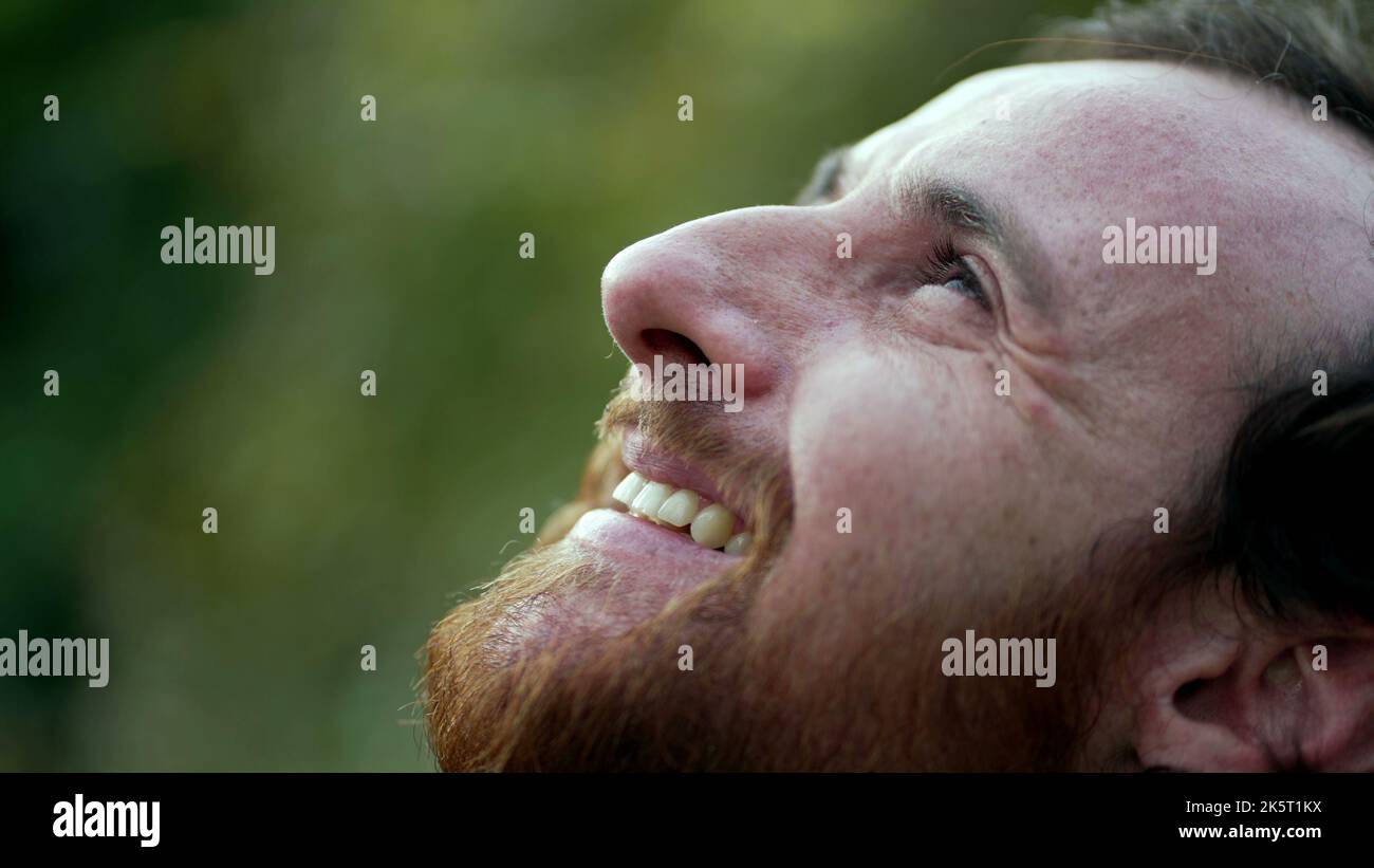 Grateful man closing eyes in meditation. Person opening eye to sky with ...