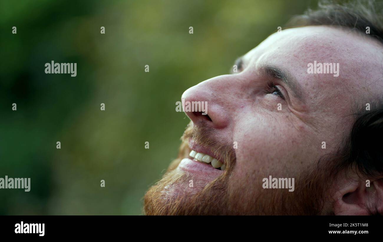 Grateful man closing eyes in meditation. Person opening eye to sky with ...
