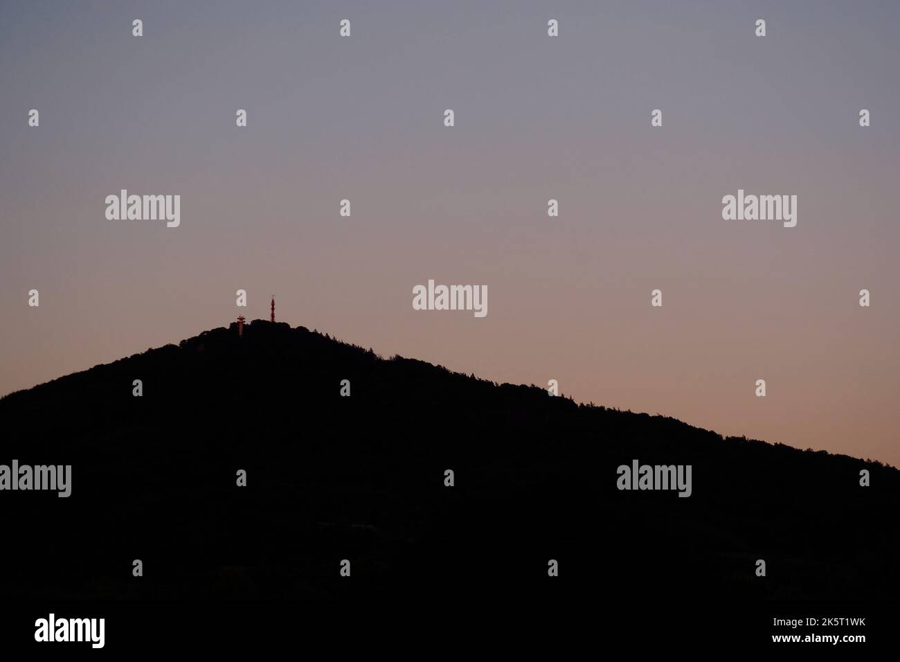 A high mountain in a shadow at sunset with a purple sky in the ...
