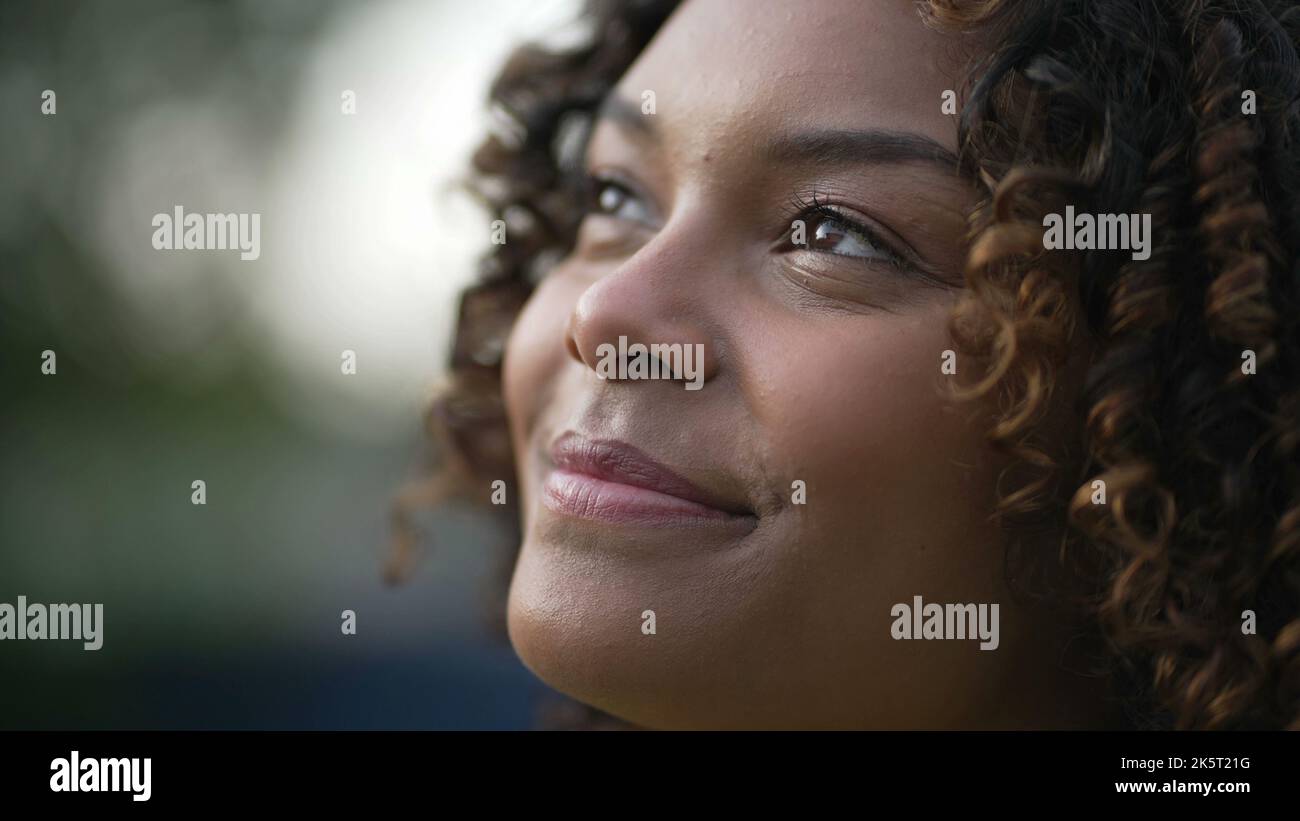 Meditative African American young woman closing eyes in contemplation ...