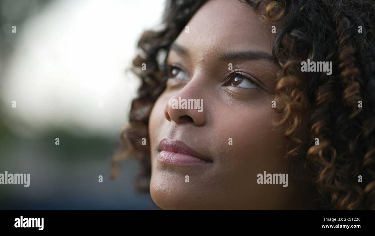 Meditative African American young woman closing eyes in contemplation ...