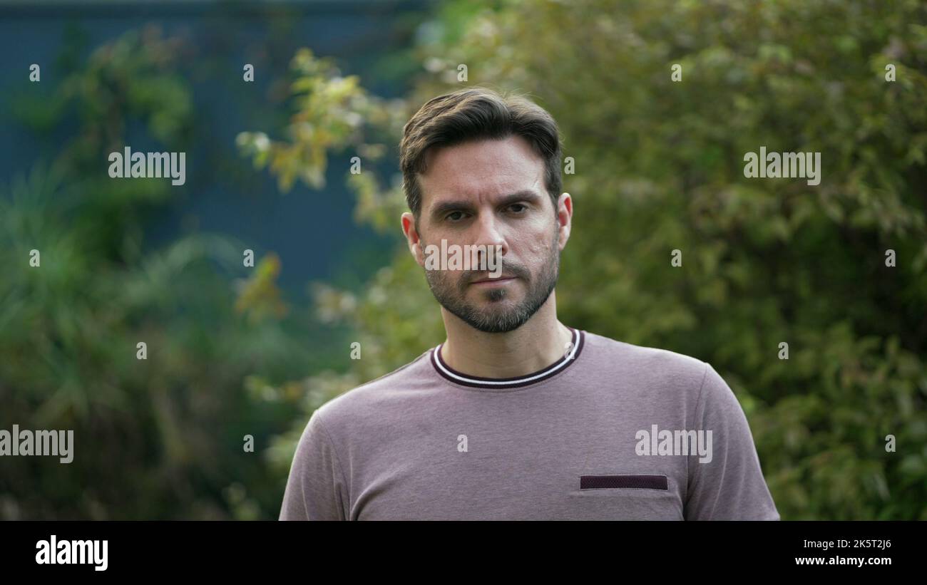 Thoughtful man standing outdoors in mental reflection. Pensive male ...