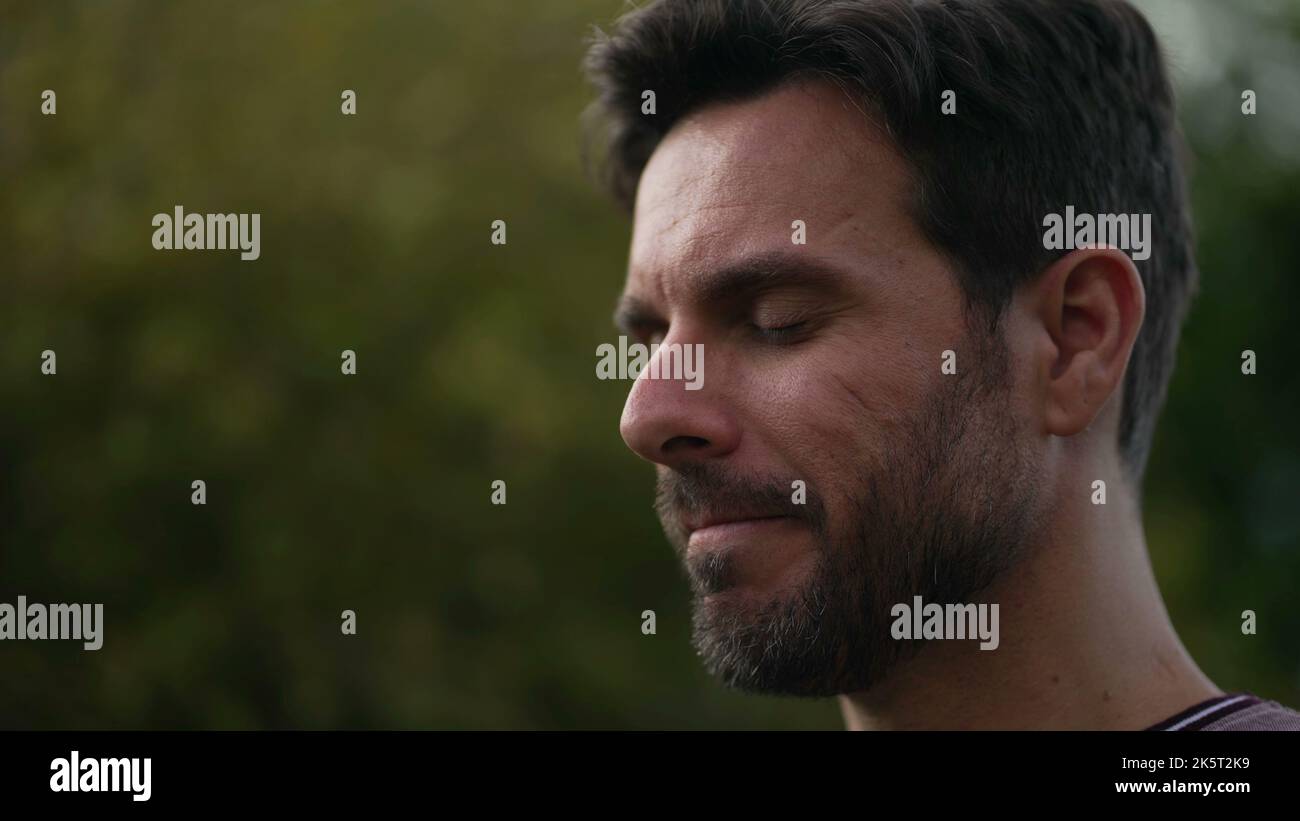 Spiritual man closing eyes in contemplation outdoors. Carefree person ...