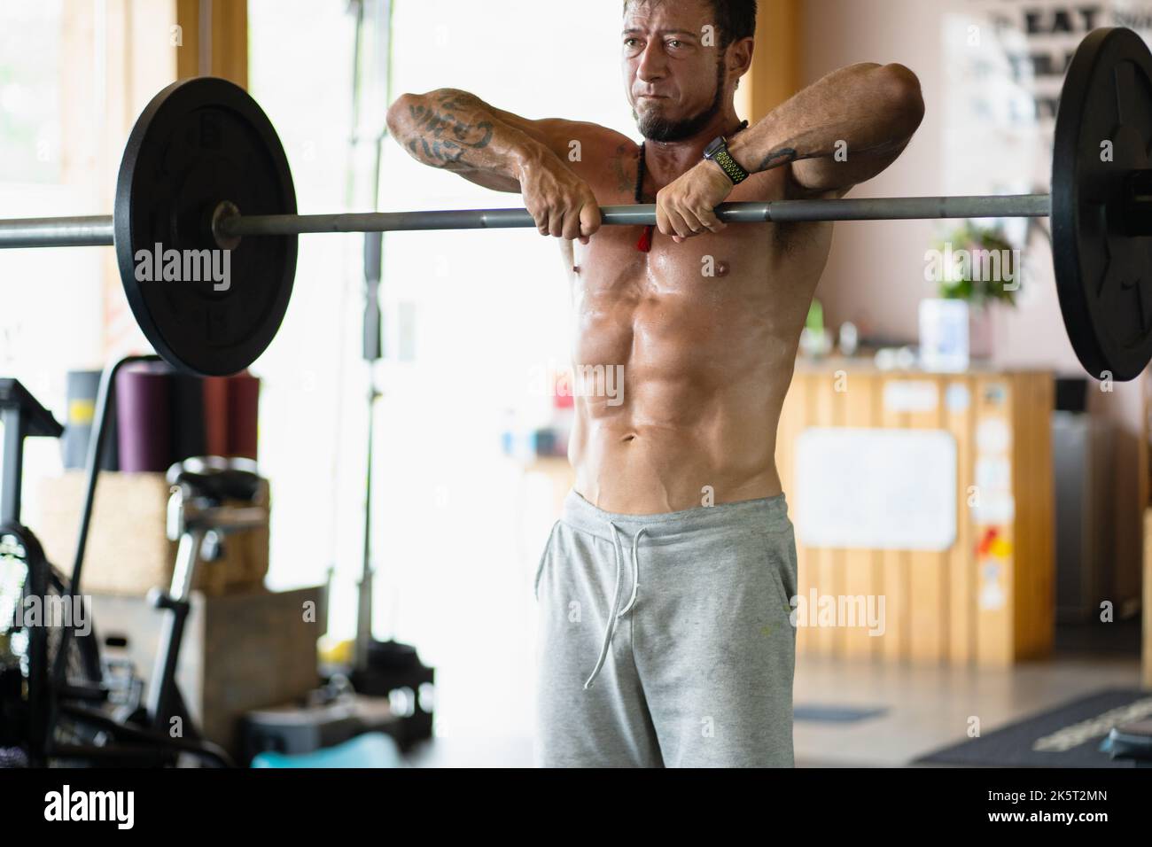 Serious strong man lifting weights in a gym Stock Photo - Alamy
